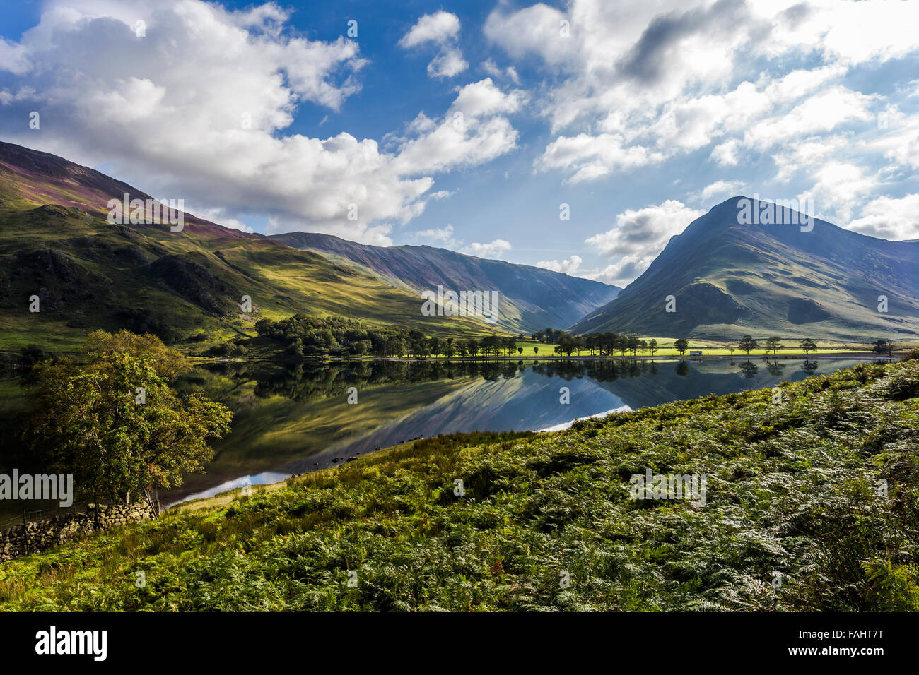 Lake Buttermere reflecting the surrounding hills on a bright sunny ...