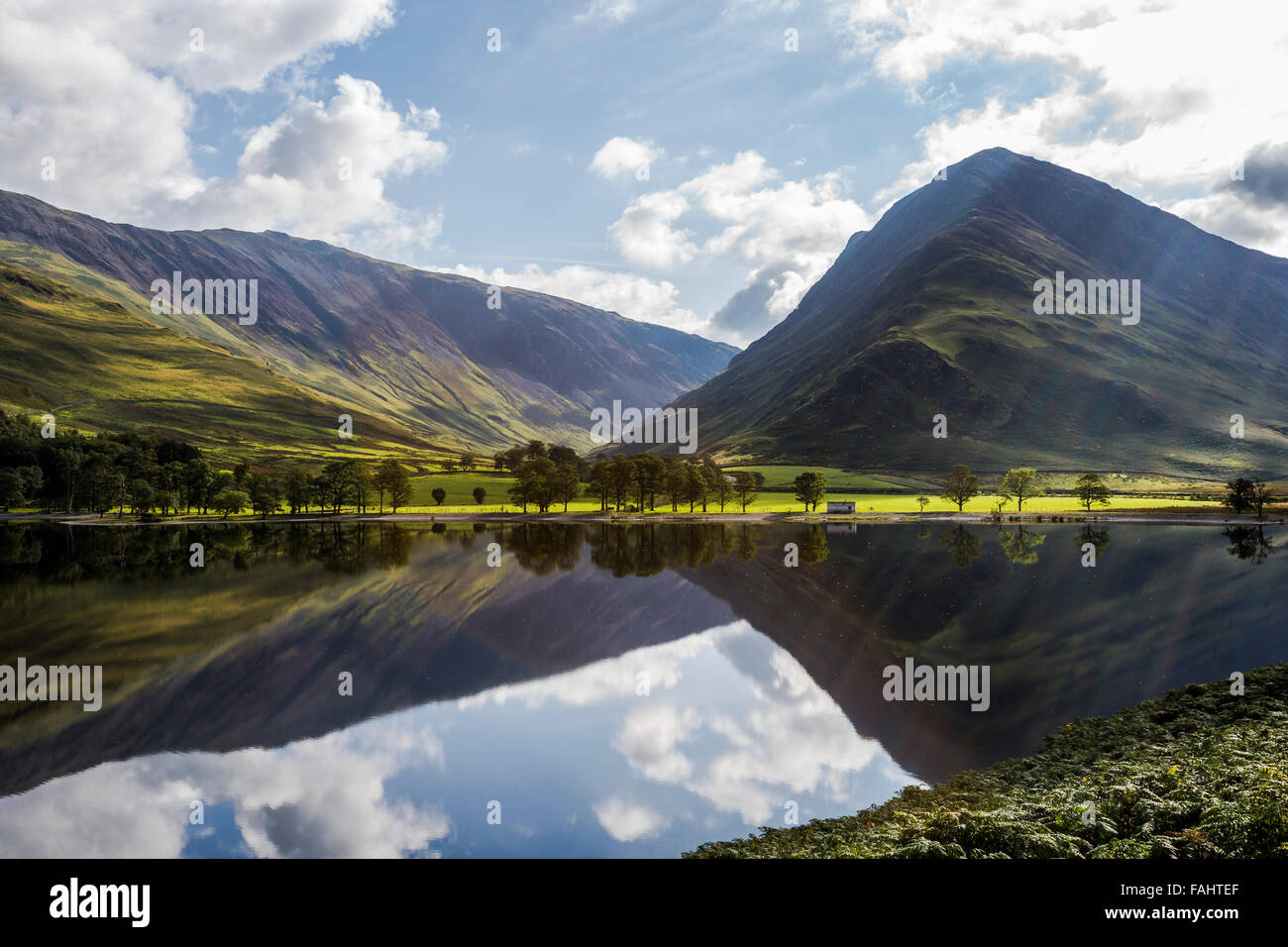Lake Buttermere reflecting the surrounding hills on a bright sunny ...