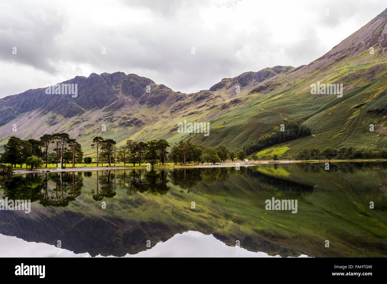 Lake Buttermere reflecting the surrounding hills on a bright sunny ...