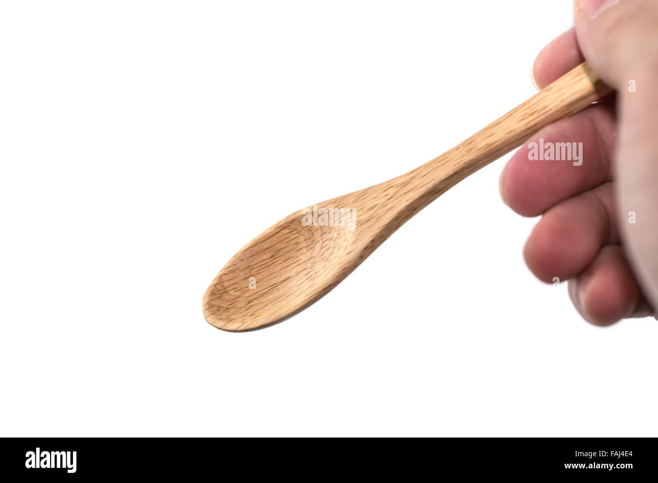 Hand holds light brown spoon made from wood on white background Stock ...