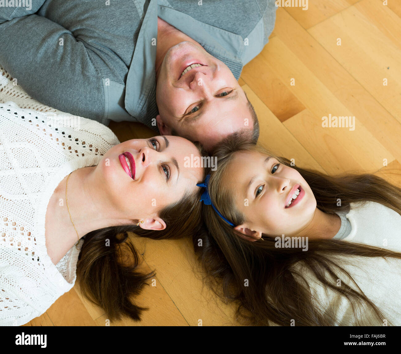 Portrait of mother, father and smiling girl together indoors Stock ...
