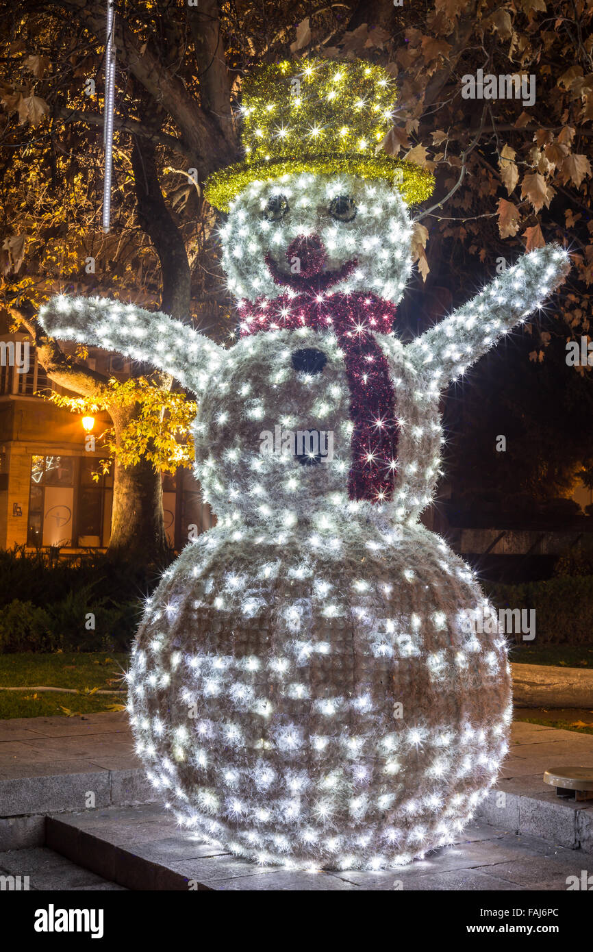 Snowman statue decorated with a lot of lights Stock Photo - Alamy