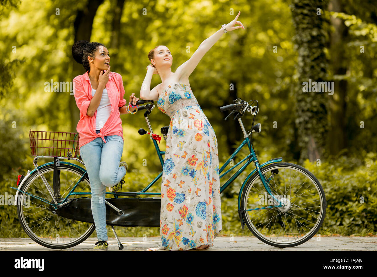 Young women posing by the bicycle Stock Photo - Alamy