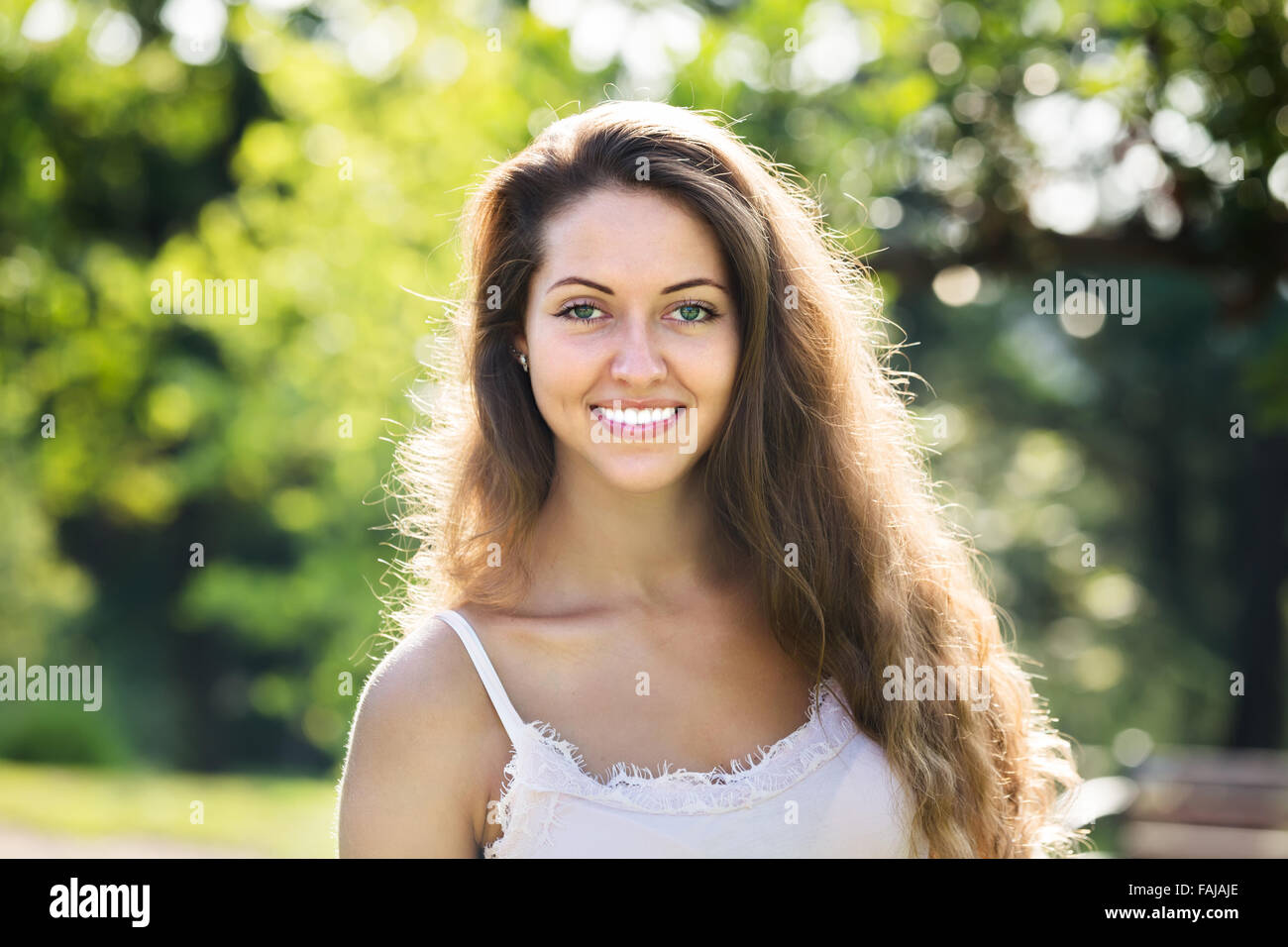 Outdoor portrait of smiling long-haired young woman Stock Photo - Alamy