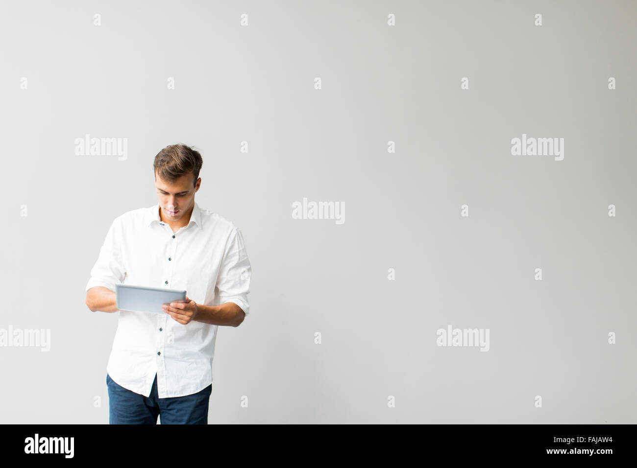 Man with tablet by the wall Stock Photo - Alamy