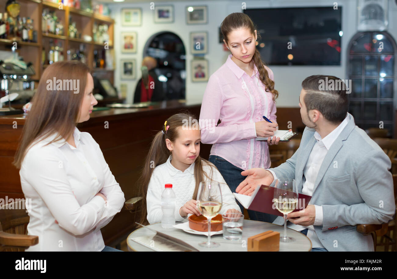 Cafe guests sitting at table and showing service discontent. Selective ...