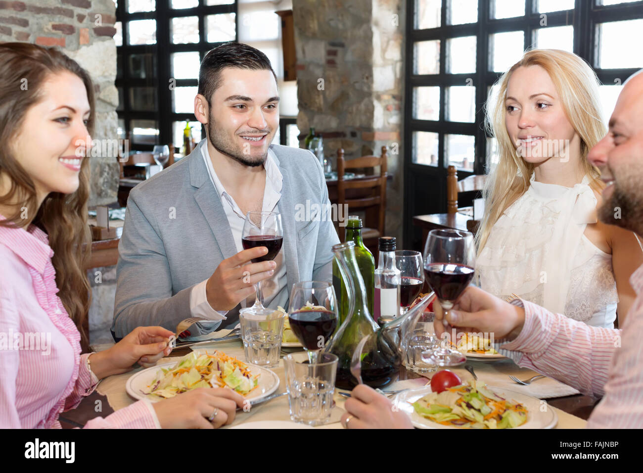 Two relaxed married couple sitting at restaurant table Stock Photo - Alamy