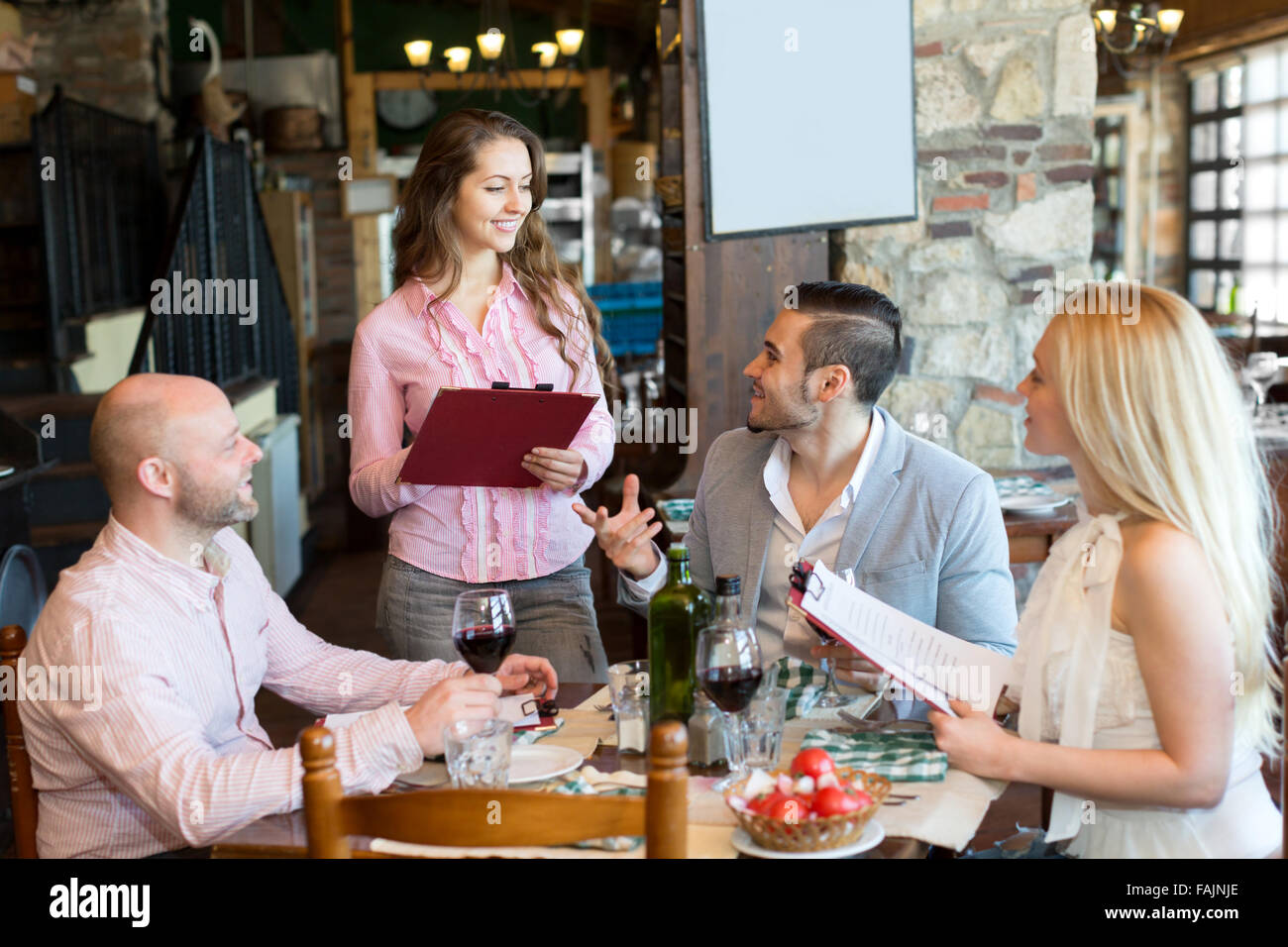 Happy group people having dinner at rural restaurant. Focus on the ...