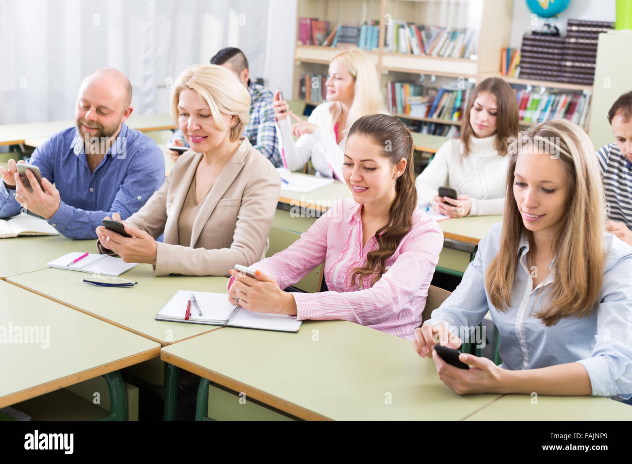 Professionals with smartphones at training session for employees. Focus ...