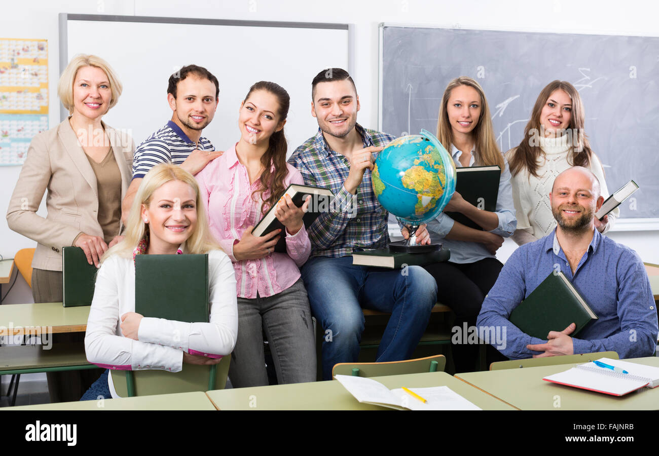 Happy professor and cheerful students posing in classroom at extension ...
