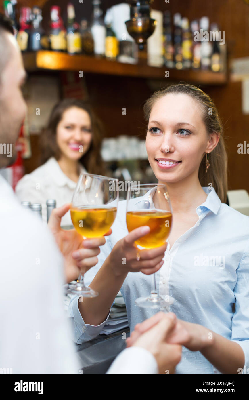 Cheerful young restaurant visitors waiting for table and drinking wine ...