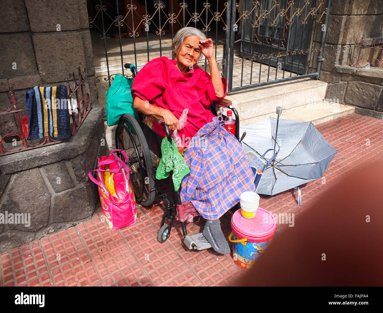 An old woman seems to have no permanent home, seeks shelter at the side ...