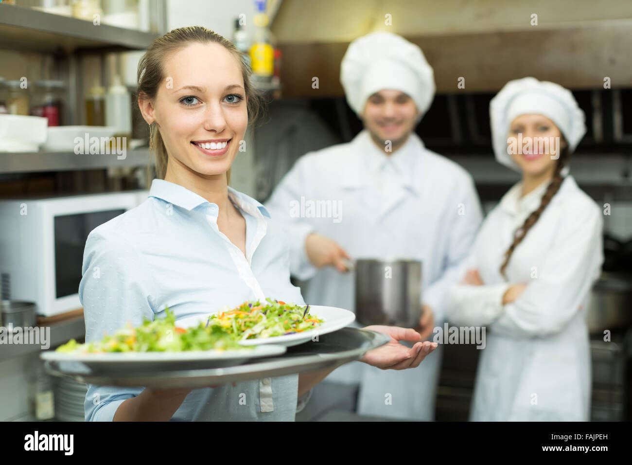 Team of chefs and female waiter at restaurant kitchen Stock Photo - Alamy
