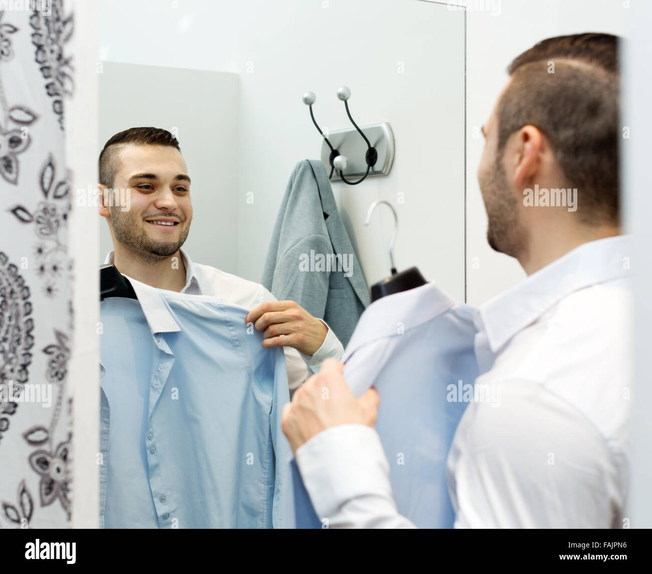 beautiful young male with new clothes at fitting-room Stock Photo - Alamy