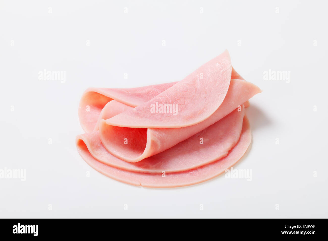 Thin slices of ham on white background Stock Photo - Alamy