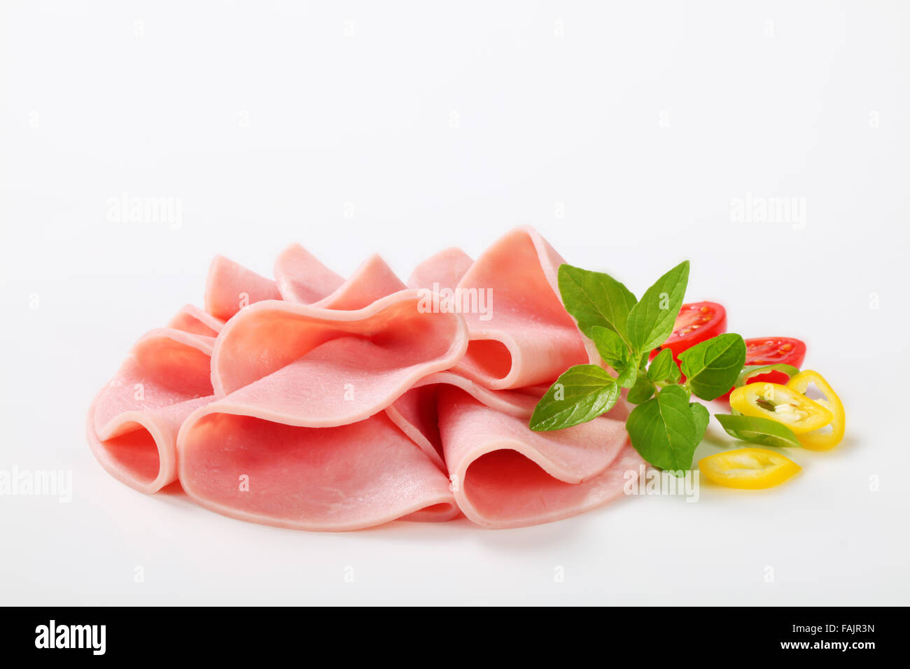 Thin slices of ham on white background Stock Photo - Alamy