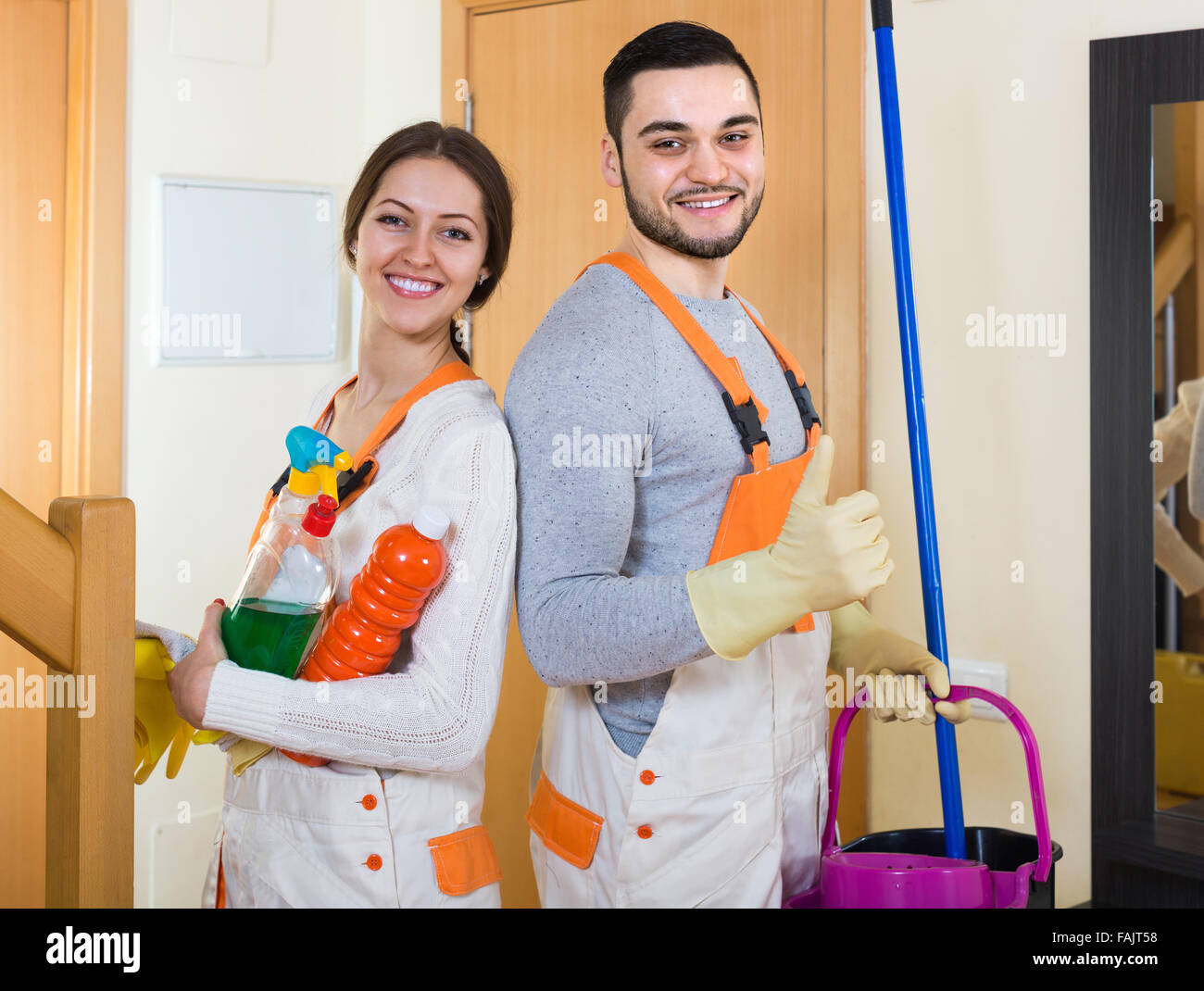 Portrait of professional cleaners with equipment at the doors of client ...