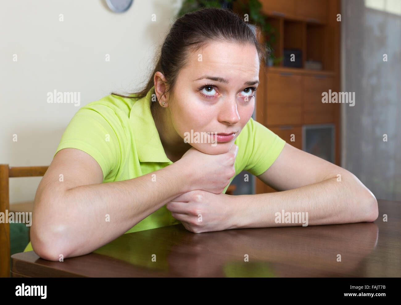 Sad and lonely woman sitting at the table at home Stock Photo - Alamy