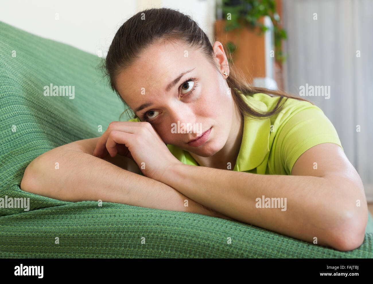Depressed female sitting in silence and thinking about her problems at ...