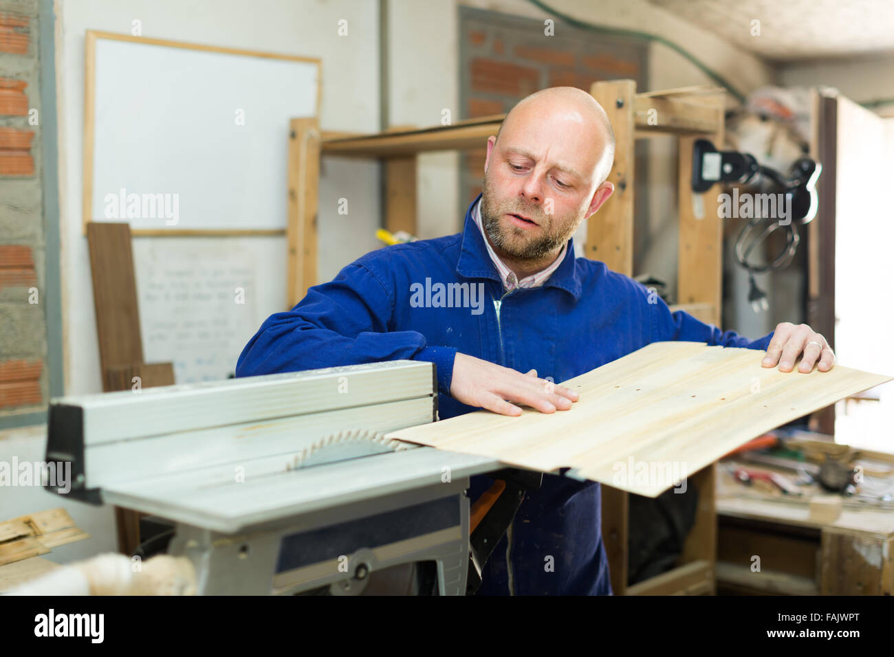 Portrait of woodworker working on a machine at wood workshop Stock ...