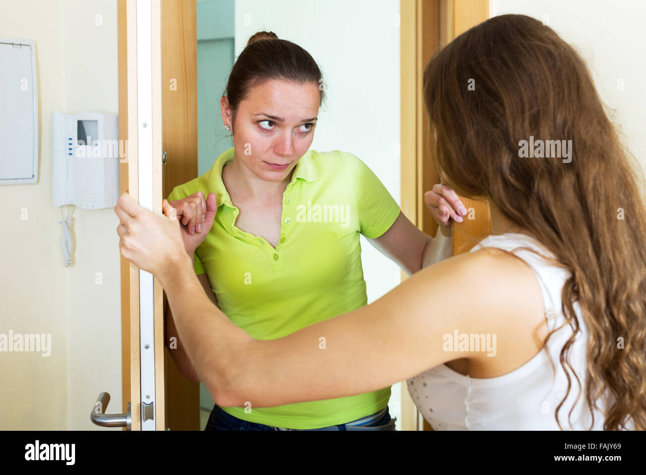 Sad girl visiting neighbour at the door Stock Photo - Alamy