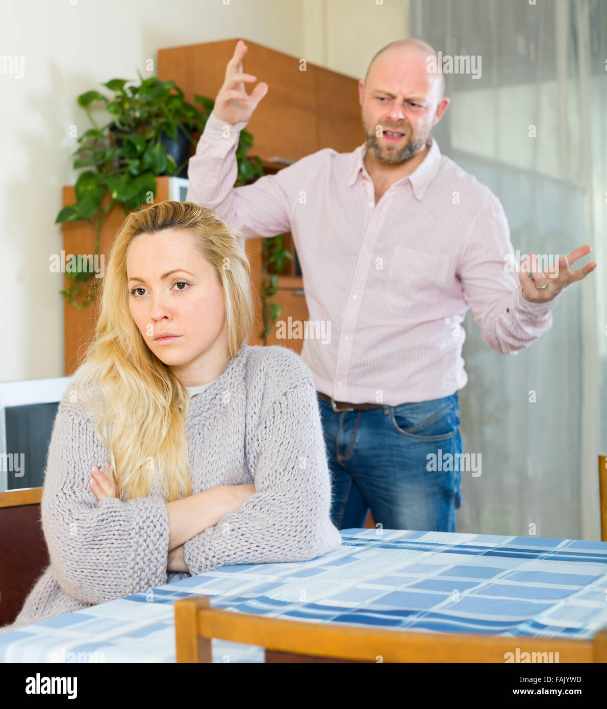 Angry man and young sad woman having quarrel at home Stock Photo - Alamy