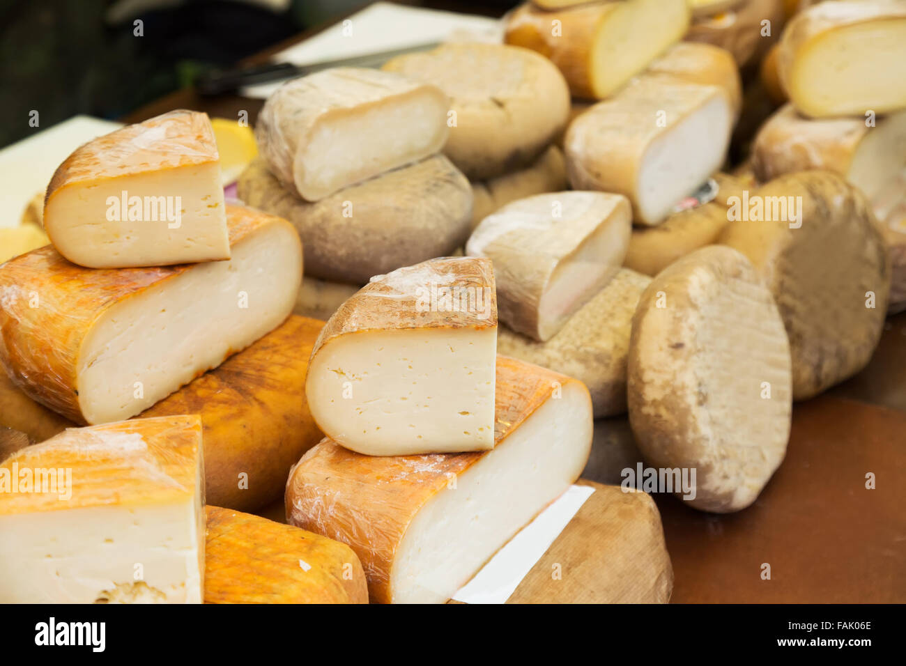 cheese in packs and in bulk at market counter Stock Photo - Alamy