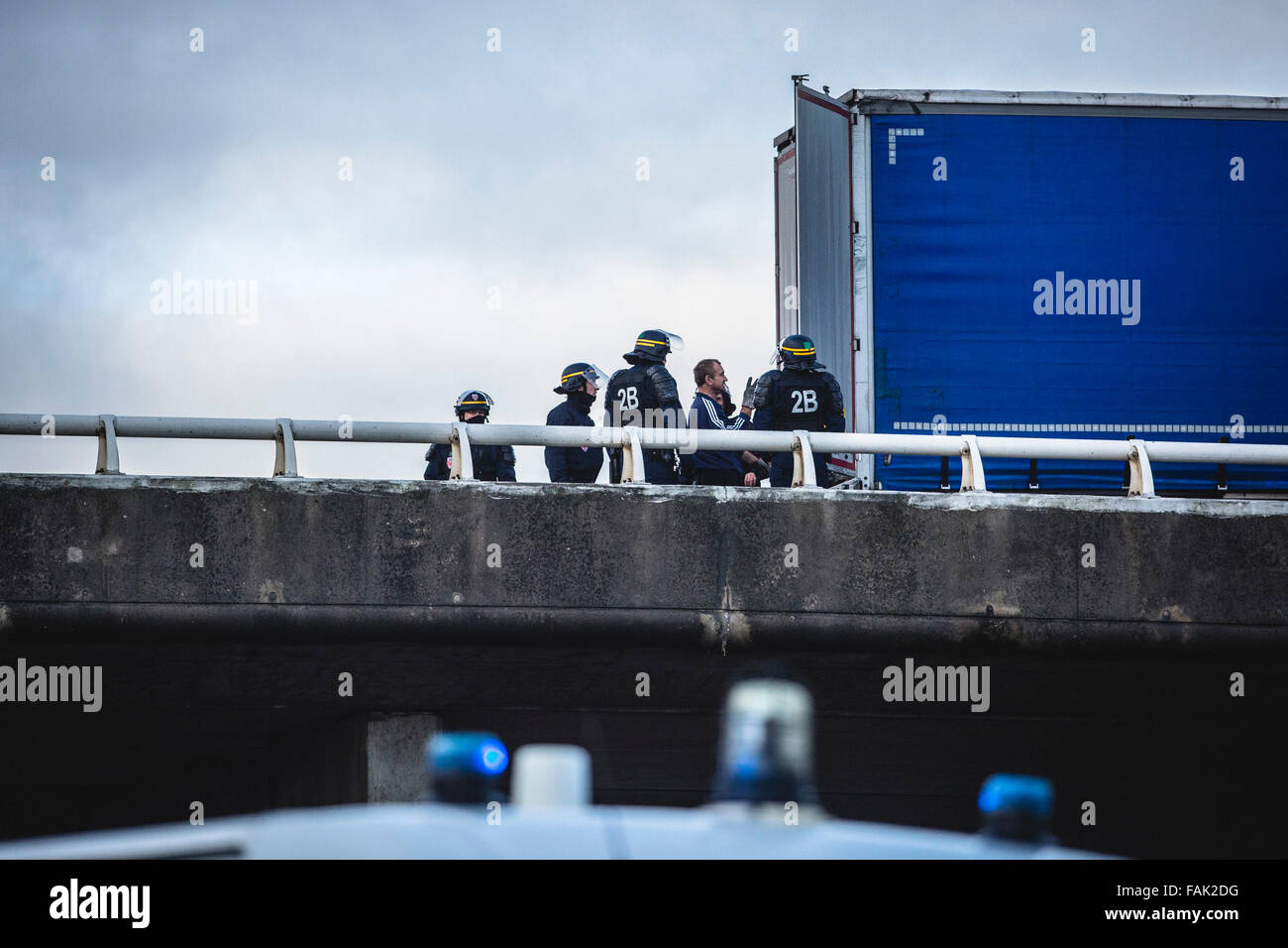 Police officers check the back of a lorry after they suspect a migrant ...
