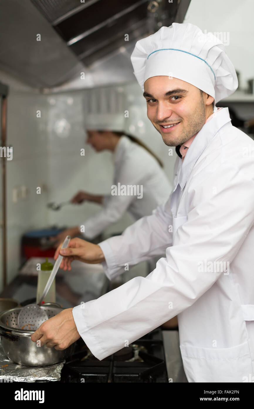 Chef and his assistant preparing meal in restaurant. Focus on man Stock ...