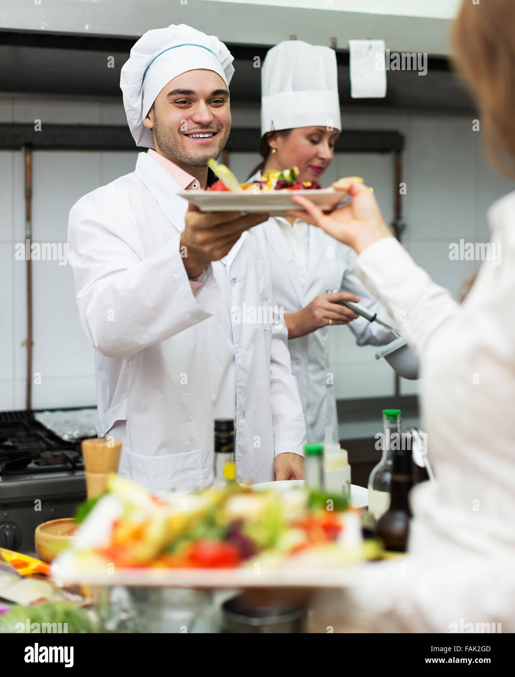 Cook gives to charming waitress plates with prepared meal Stock Photo ...