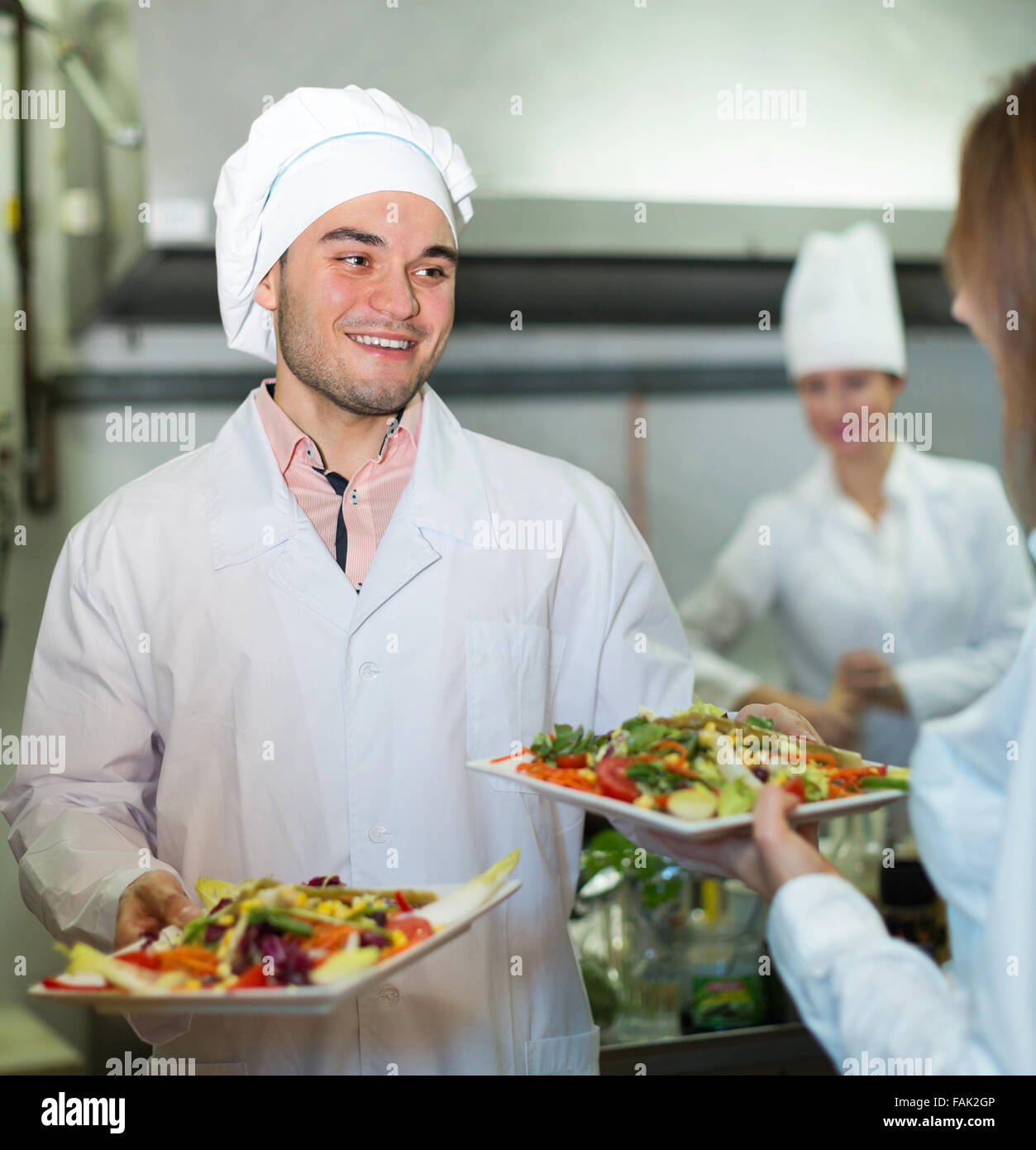 Team of chefs and young waiter in the restaurant kitchen Stock Photo ...