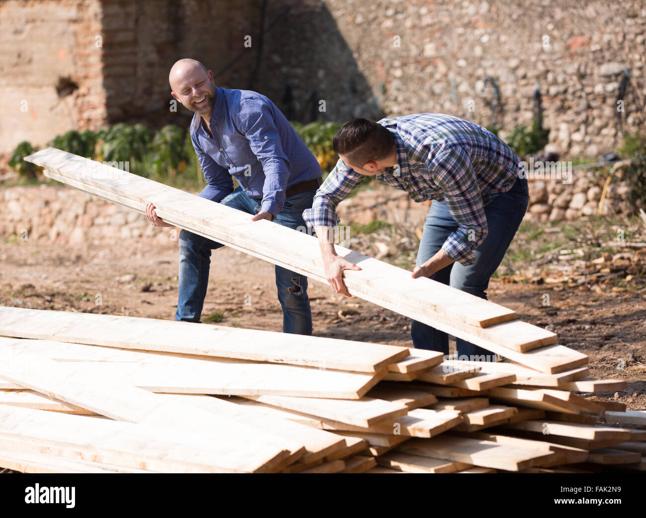 Happy american workmen arranging building timber at farm Stock Photo ...