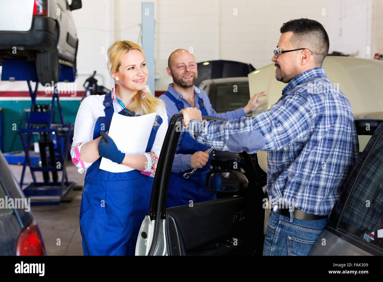 Two troubleshooters and friendly driver standing near car Stock Photo ...