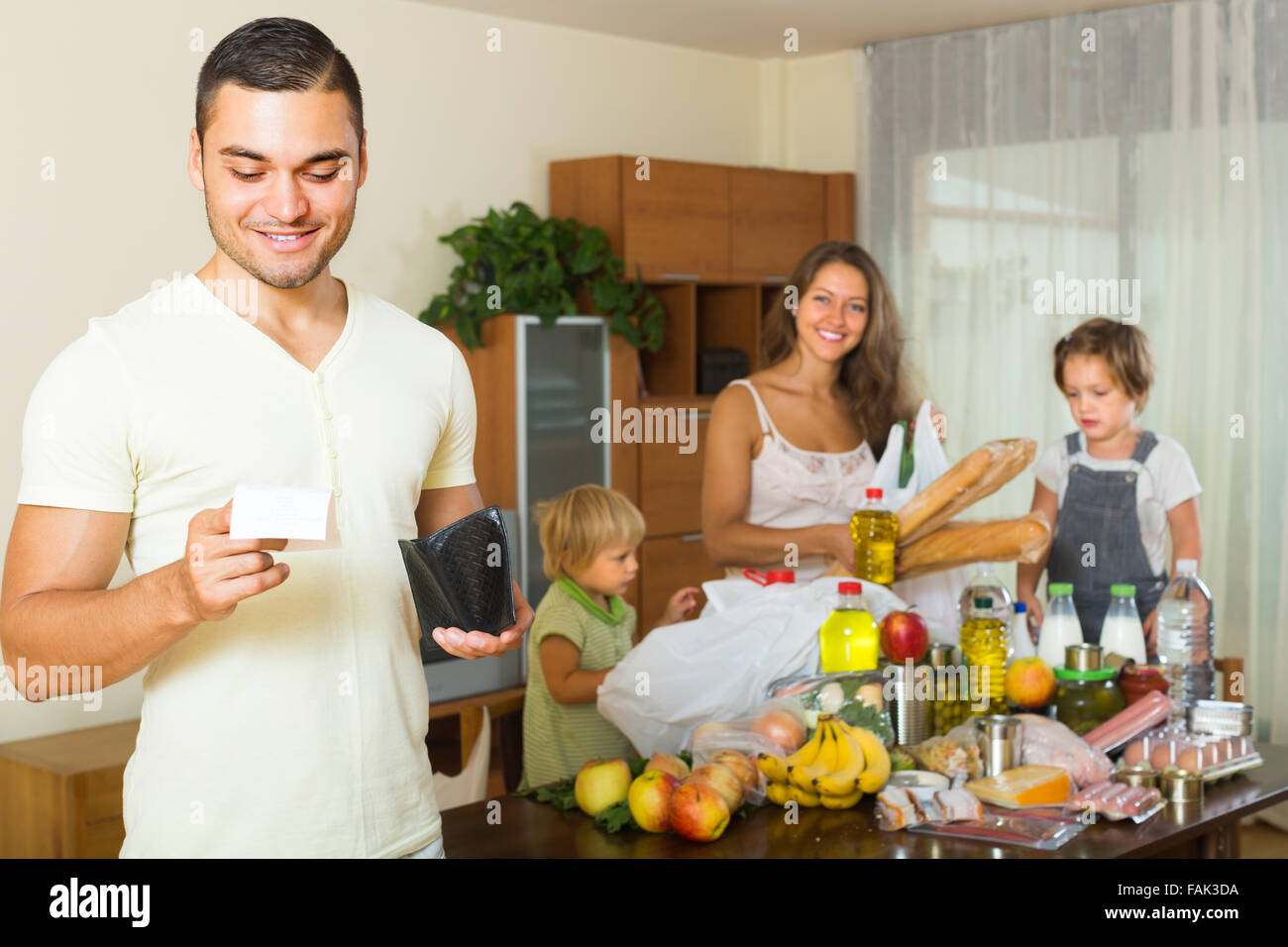Happy young man with receipt from store, family brought food home Stock ...