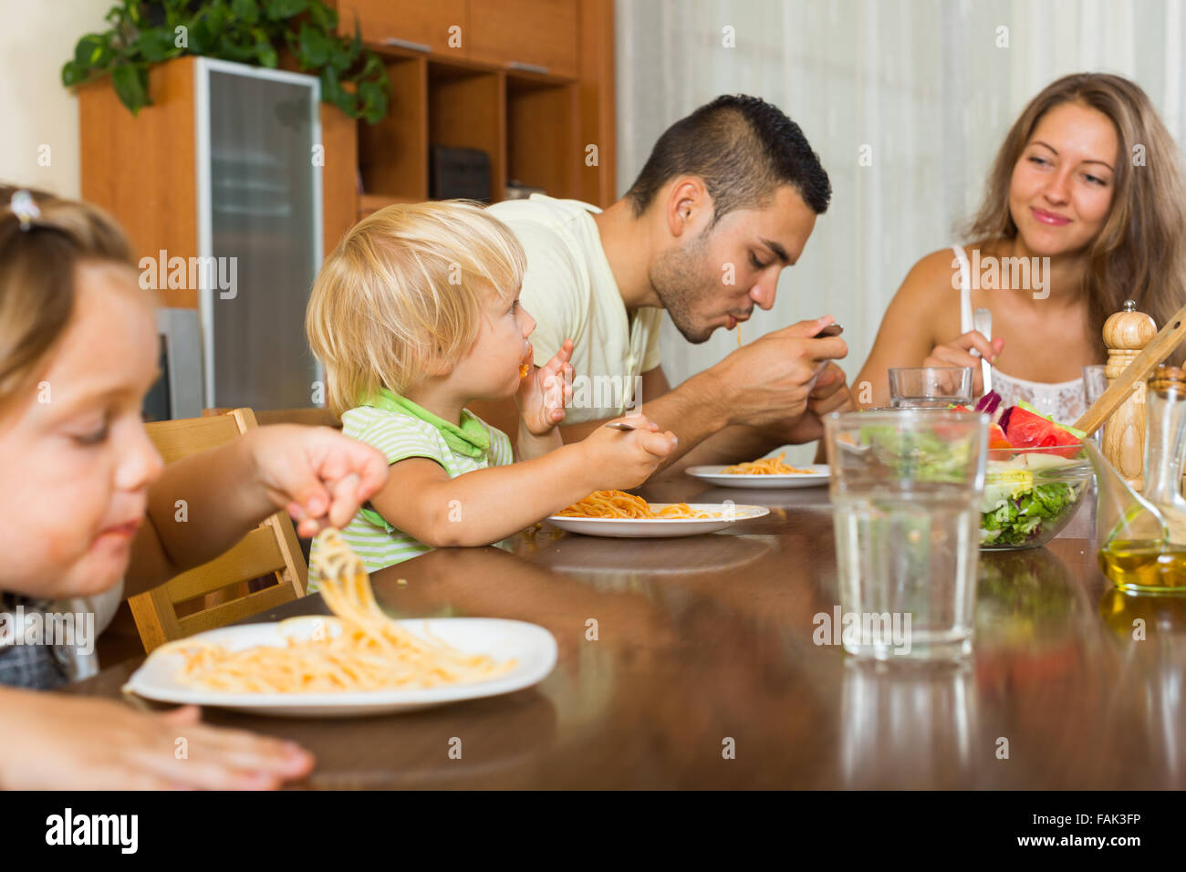 ordinary family of four eating spaghetti Stock Photo - Alamy