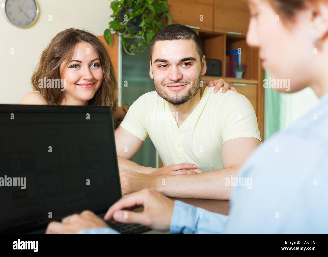 Positive couple discussing details of private insurance with agent ...