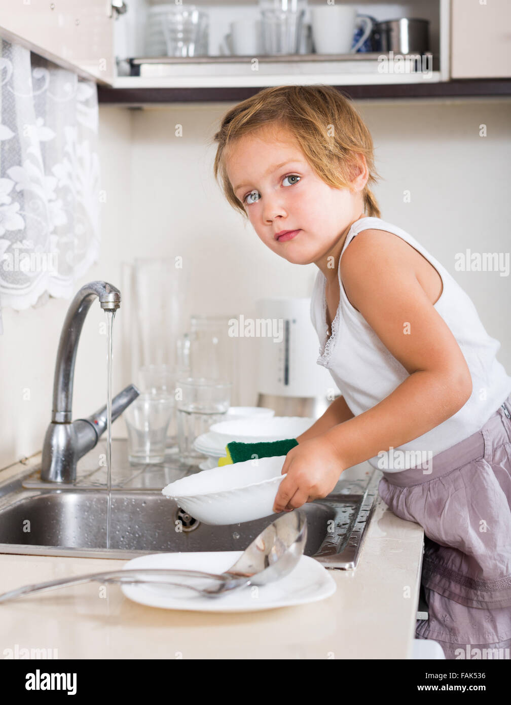 Small child washing dishes at domestic kitchen Stock Photo - Alamy