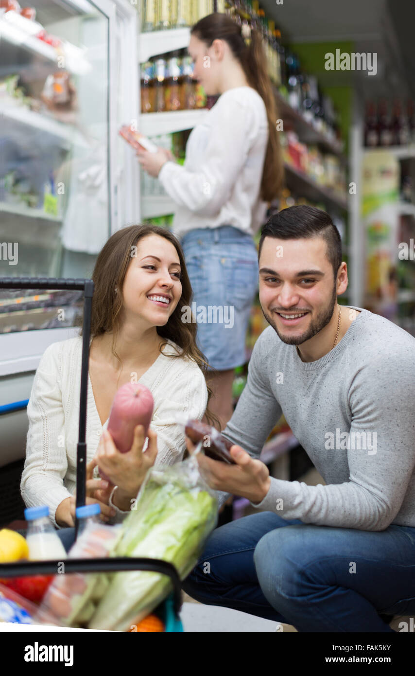 Happy customers standing near the fridge with the meat products Stock ...