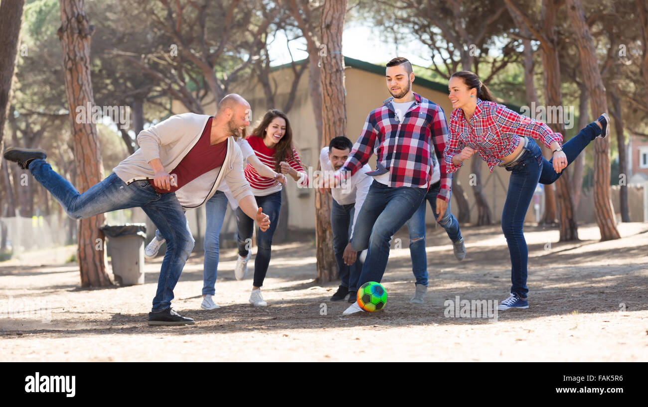 Happy active friends playing football at picnic lunch. Selective focus ...