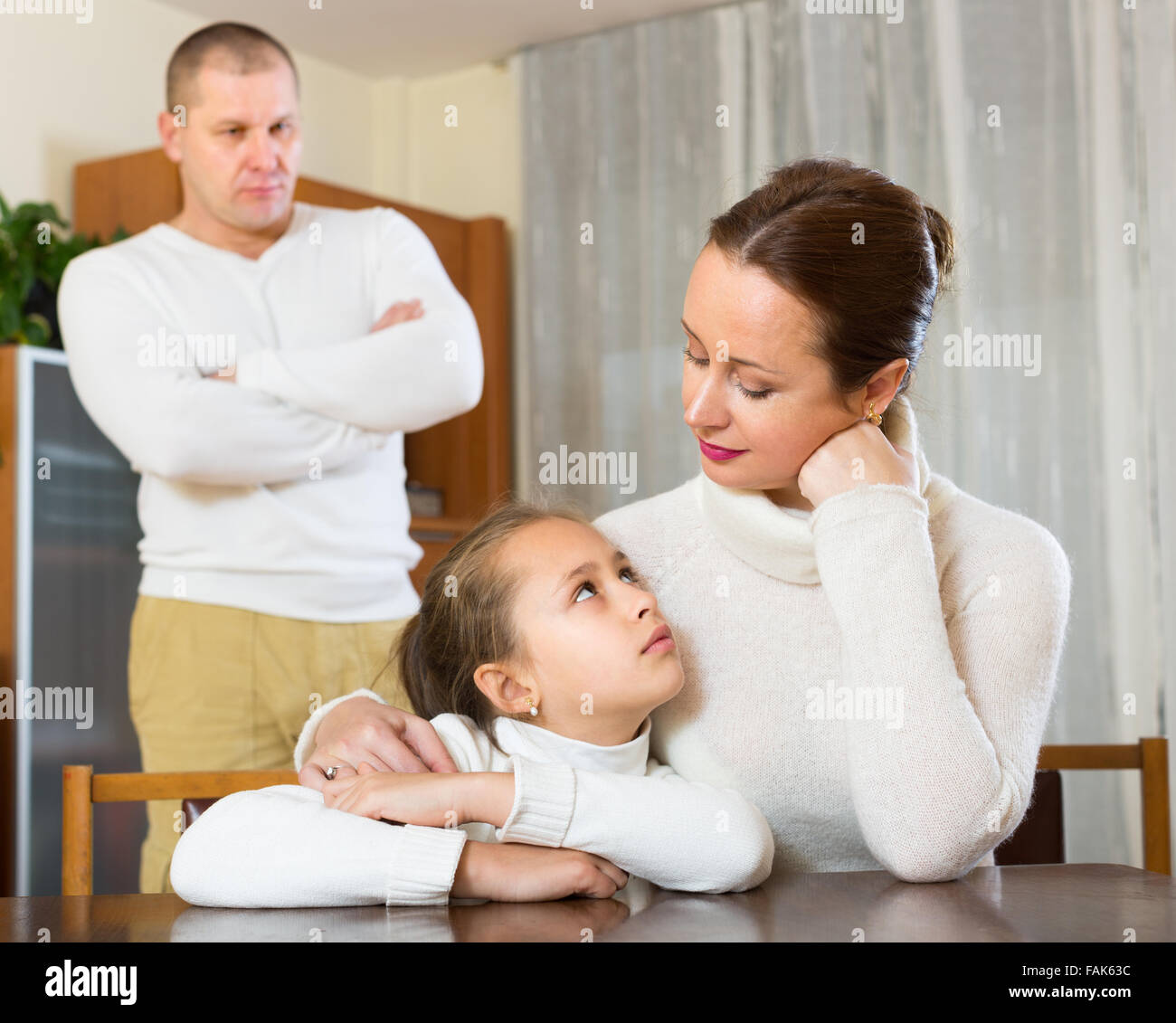 Ordinary family of three with little daughter and angry man having ...