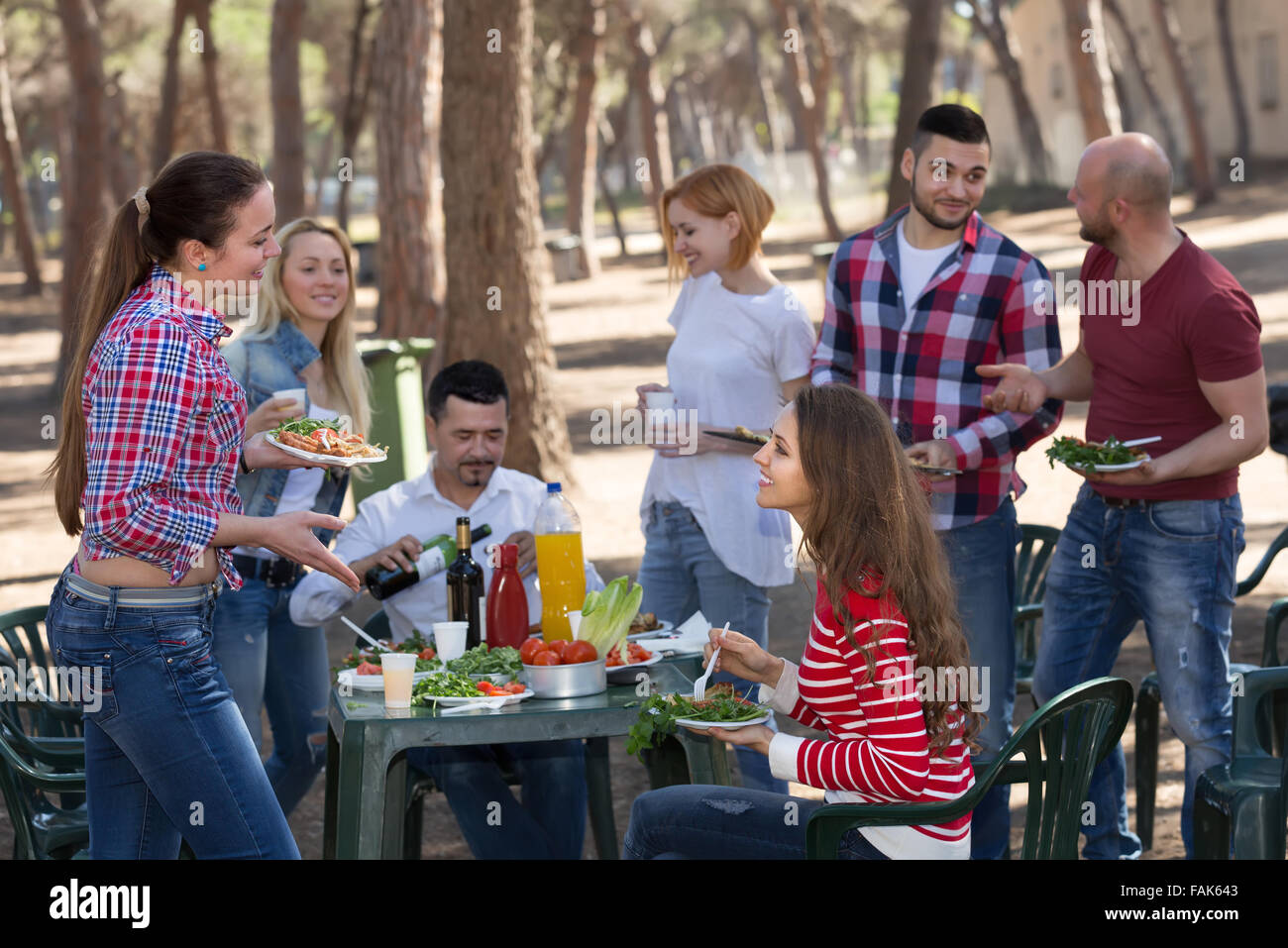 Happy colleagues making grill at summer corporate party outdoors ...