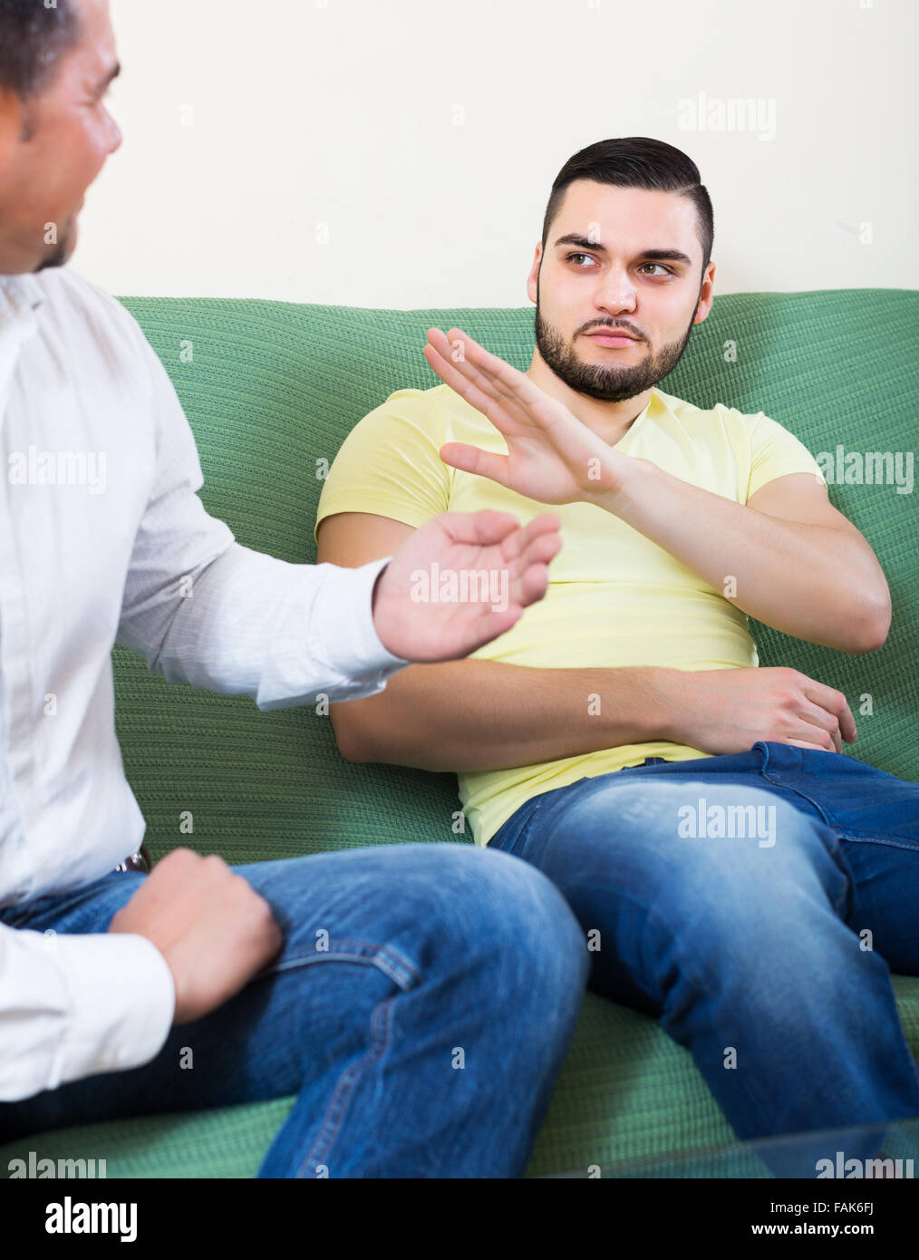 Two sad male adults arguing about something indoors Stock Photo - Alamy