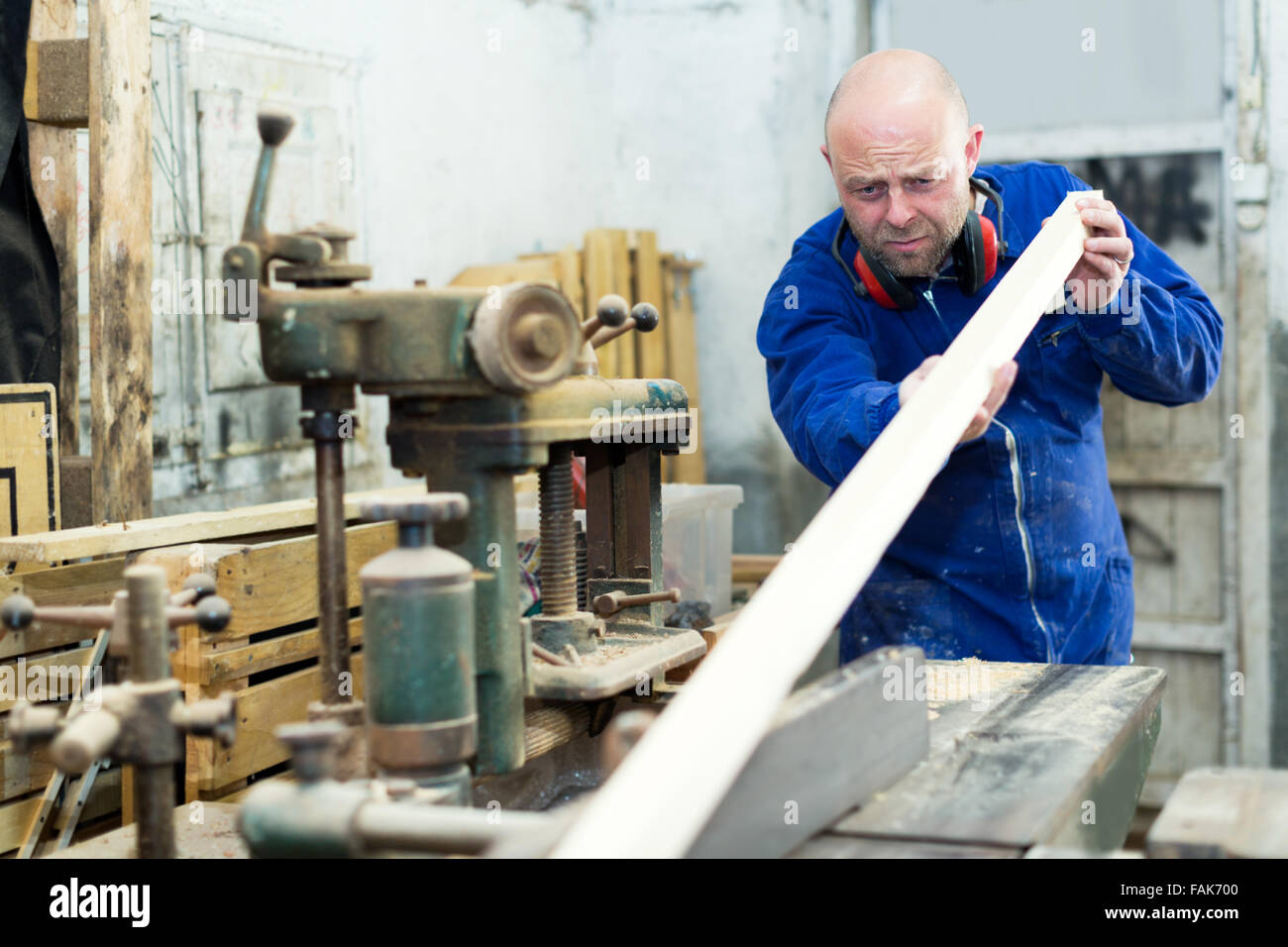 concentrated adult male worker on lathe at wood workroom Stock Photo ...