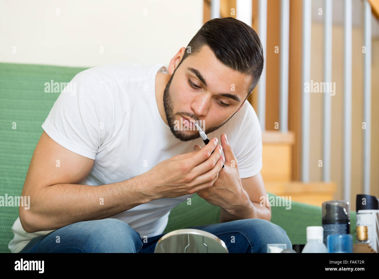 Young man shaving moustache by trimmer Stock Photo - Alamy
