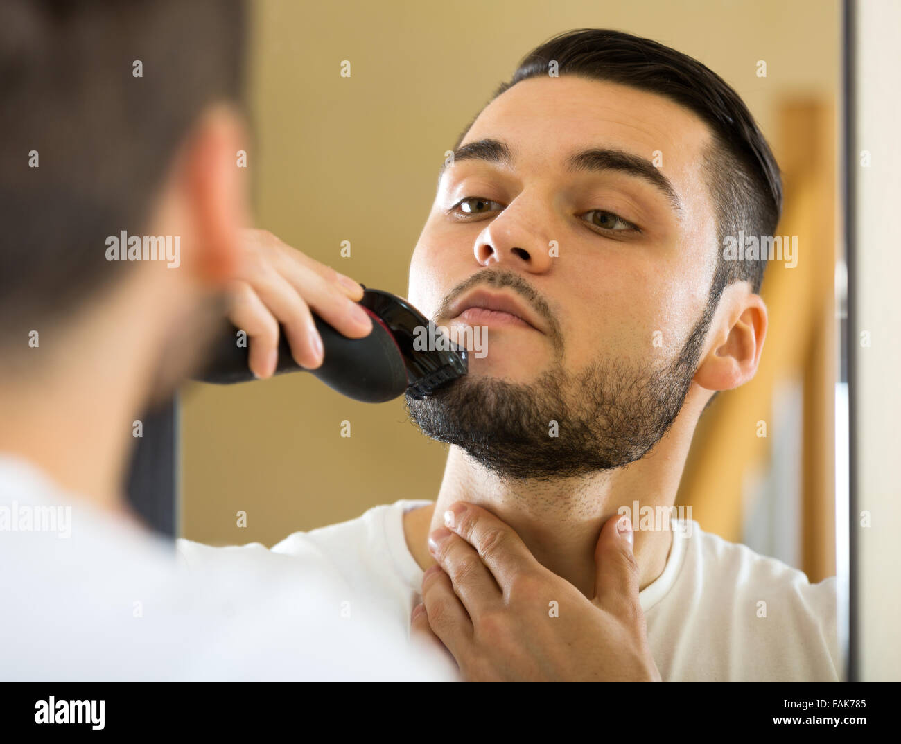 Young guy shaving by electric shaver at home Stock Photo - Alamy