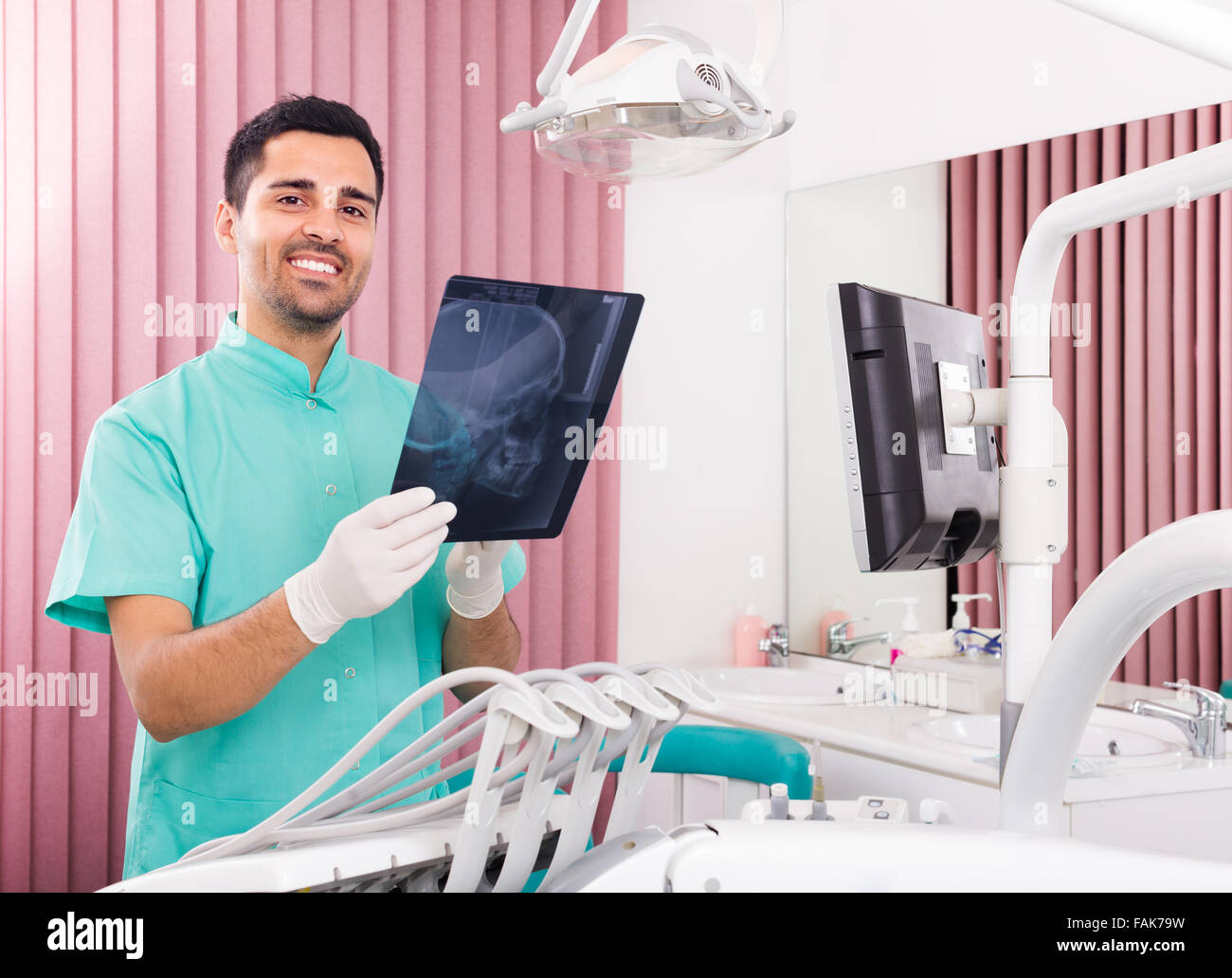 Smiling male dentist looking x-ray scan Stock Photo - Alamy