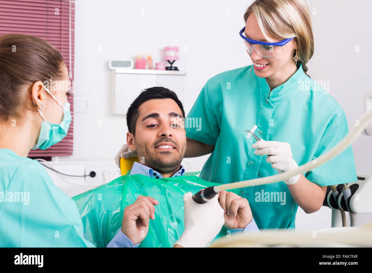 Portrait of professional doctor and frightened patient at dental clinic ...