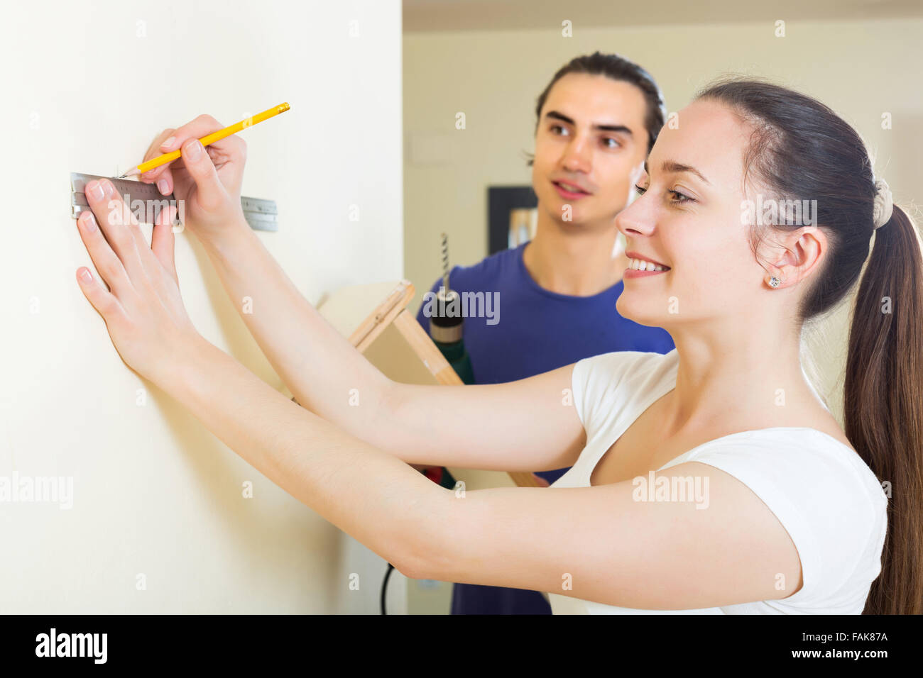 Smiling young family makes repairs at home Stock Photo - Alamy