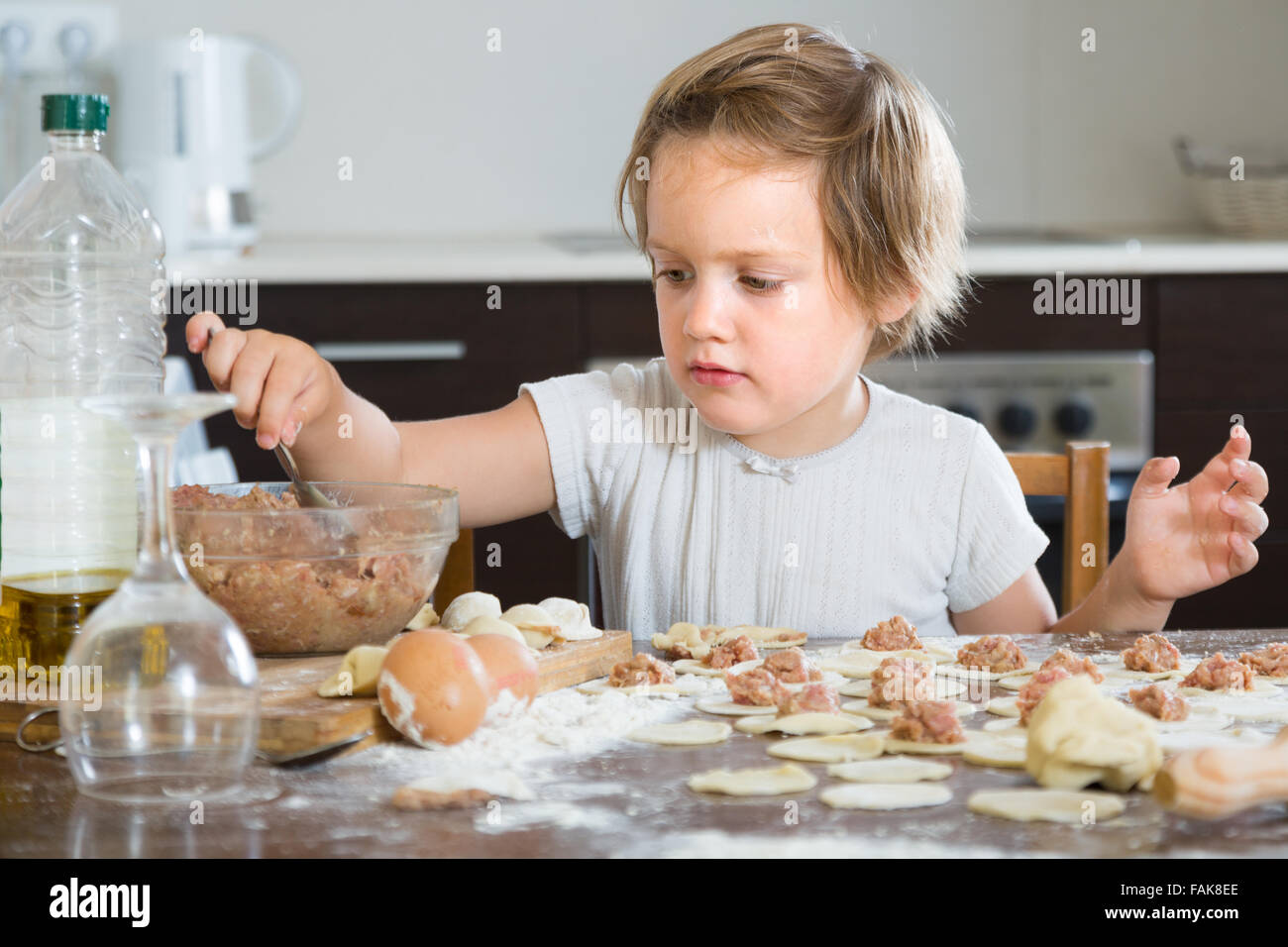 Happy child cooking meat dumplings in domestic kitchen Stock Photo - Alamy