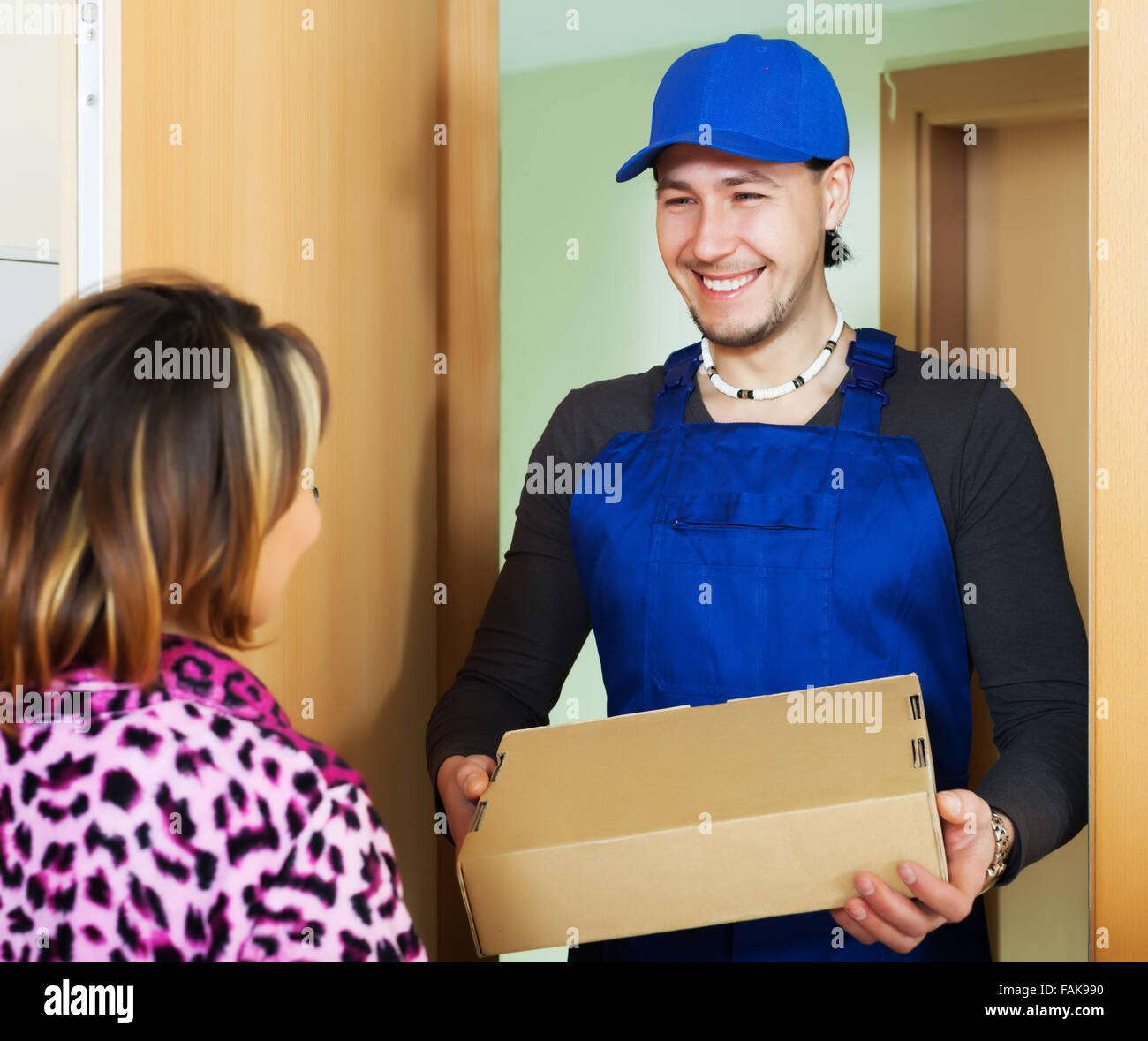 Smiling postman delivered a parcel to girl at home Stock Photo - Alamy